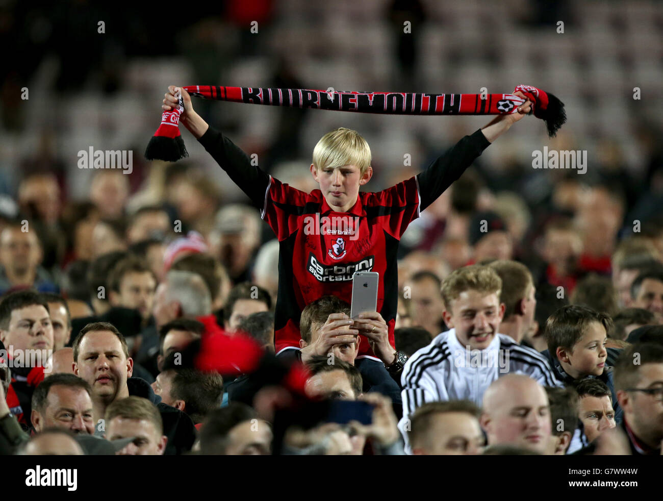Bournemouth fans celebrate on the pitch after the final whistle during ...