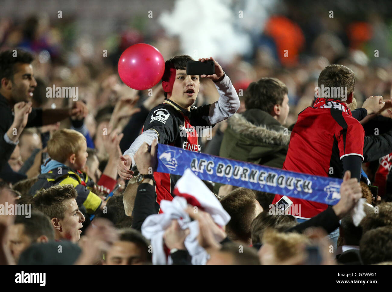 Bournemouth fans celebrate on the pitch after the final whistle during ...