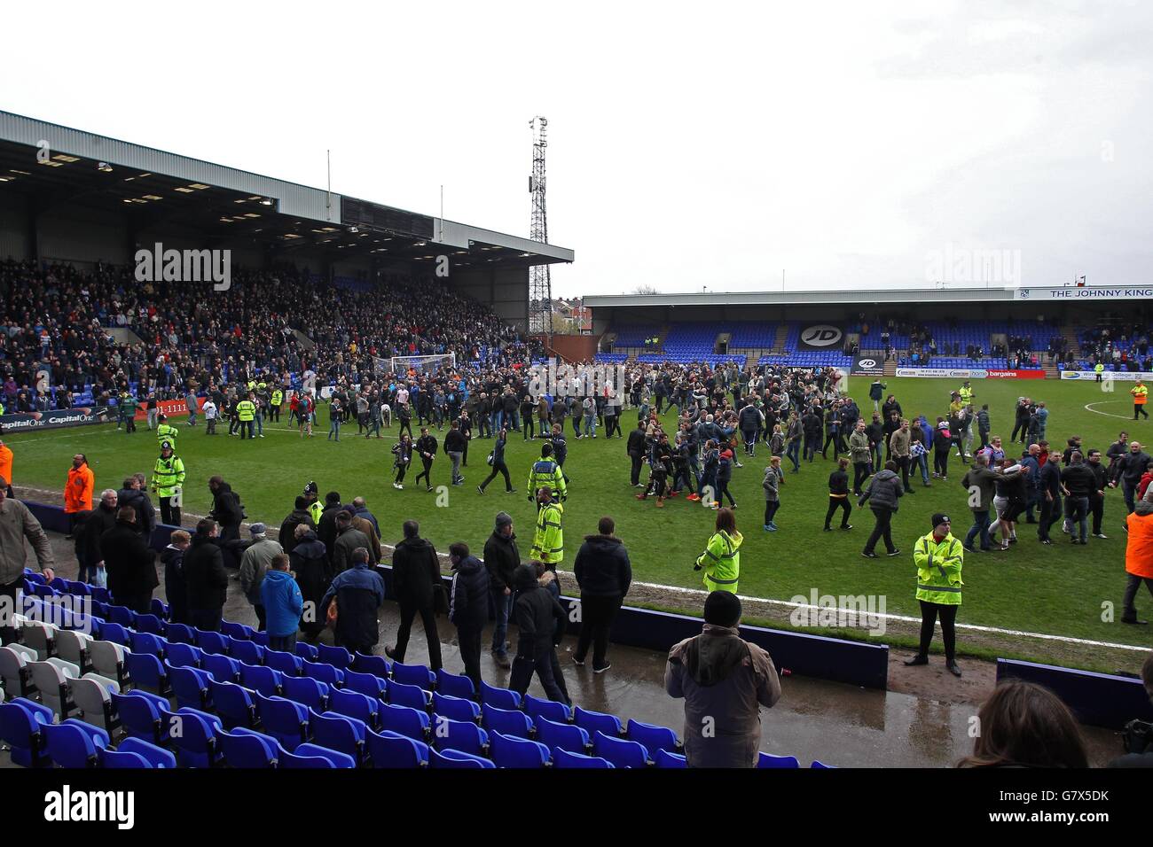 Bury fans invade the pitch at the final whistle after securing their ...