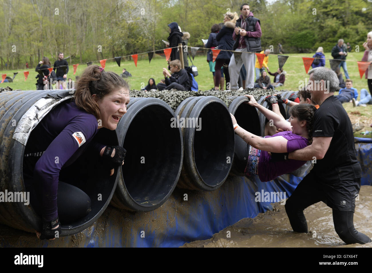 Participants emerge from 'Sewer Rat' during Tough Mudder London West at ...