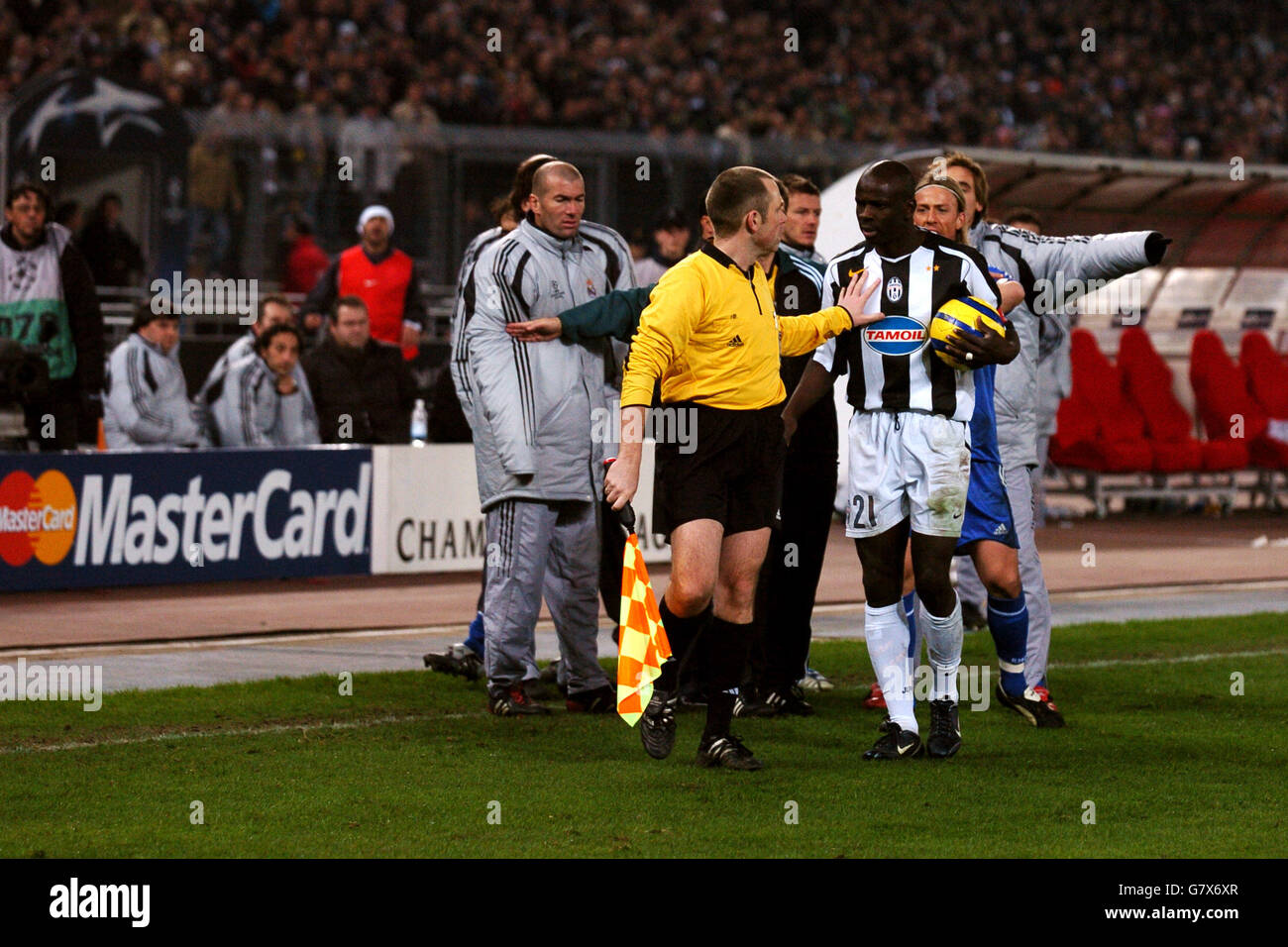 Assistant referee Christian Schraer holds off Juventus' Lilian Thuram ...