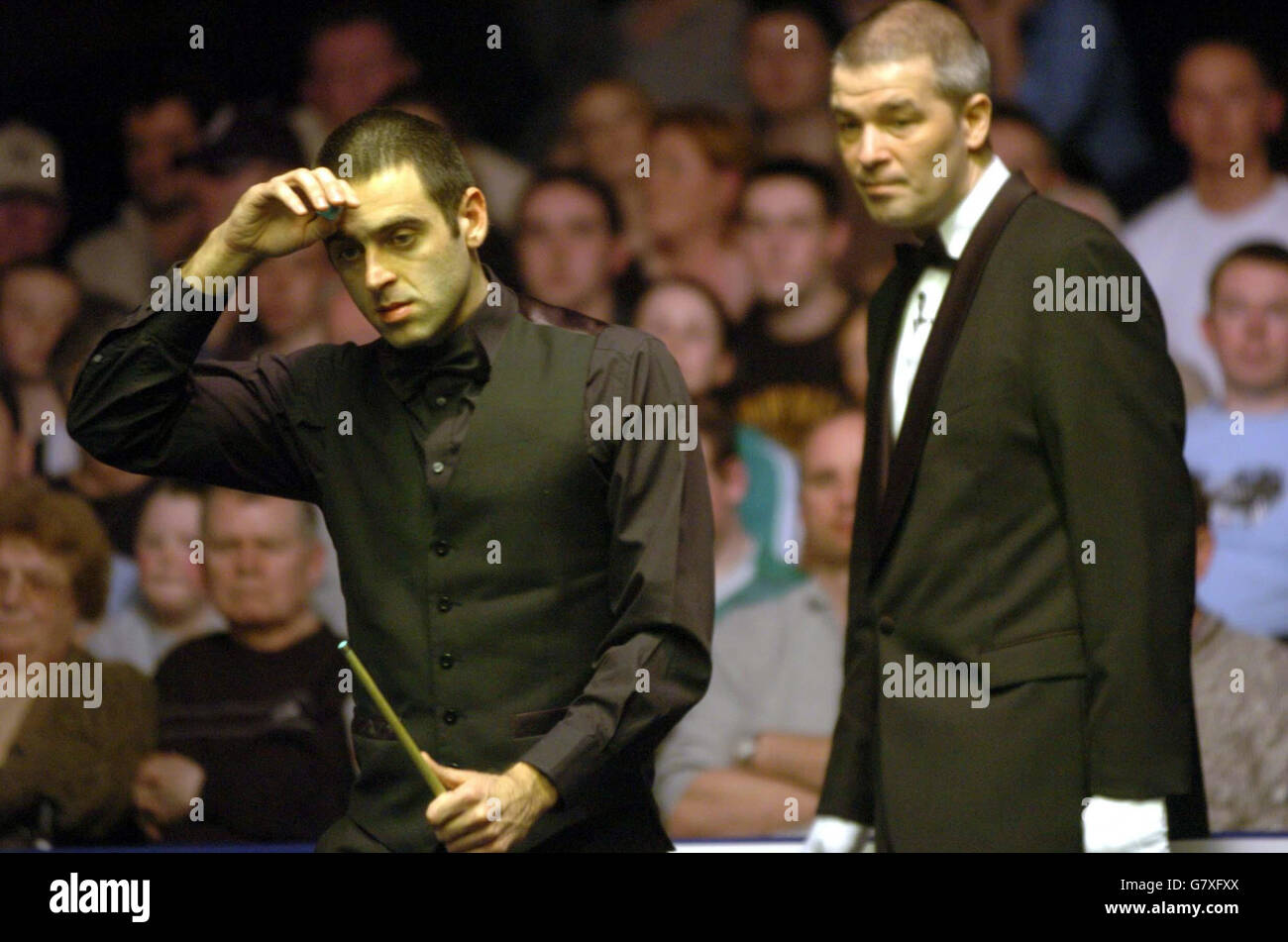 Ronnie O'Sullivan (L) ponders his next shot under the watchful eye of ...