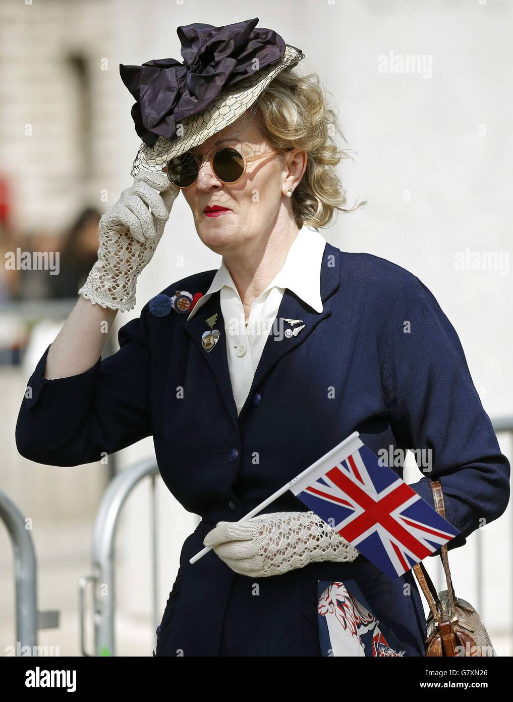 A woman wearing period clothing arrives to attend a VE Day Parade to ...