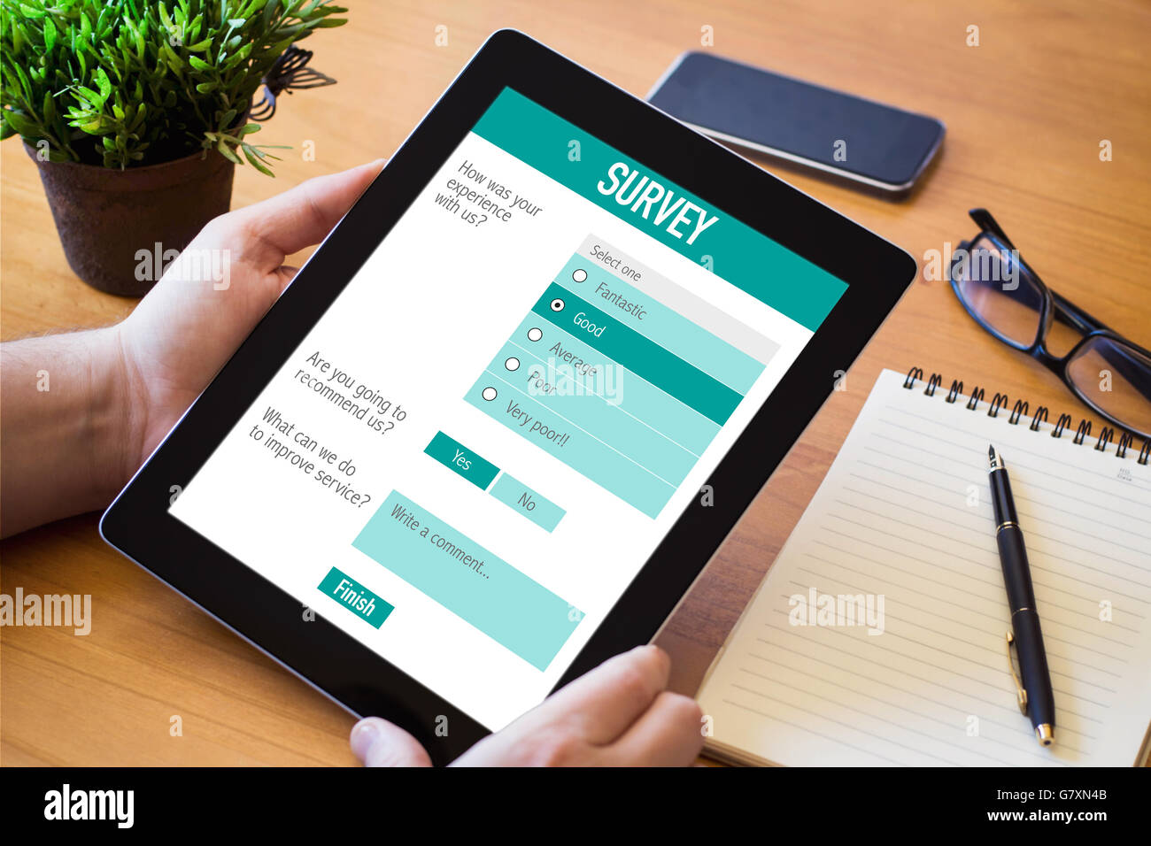 hands of a man filling online survey over a wooden workspace table. All ...