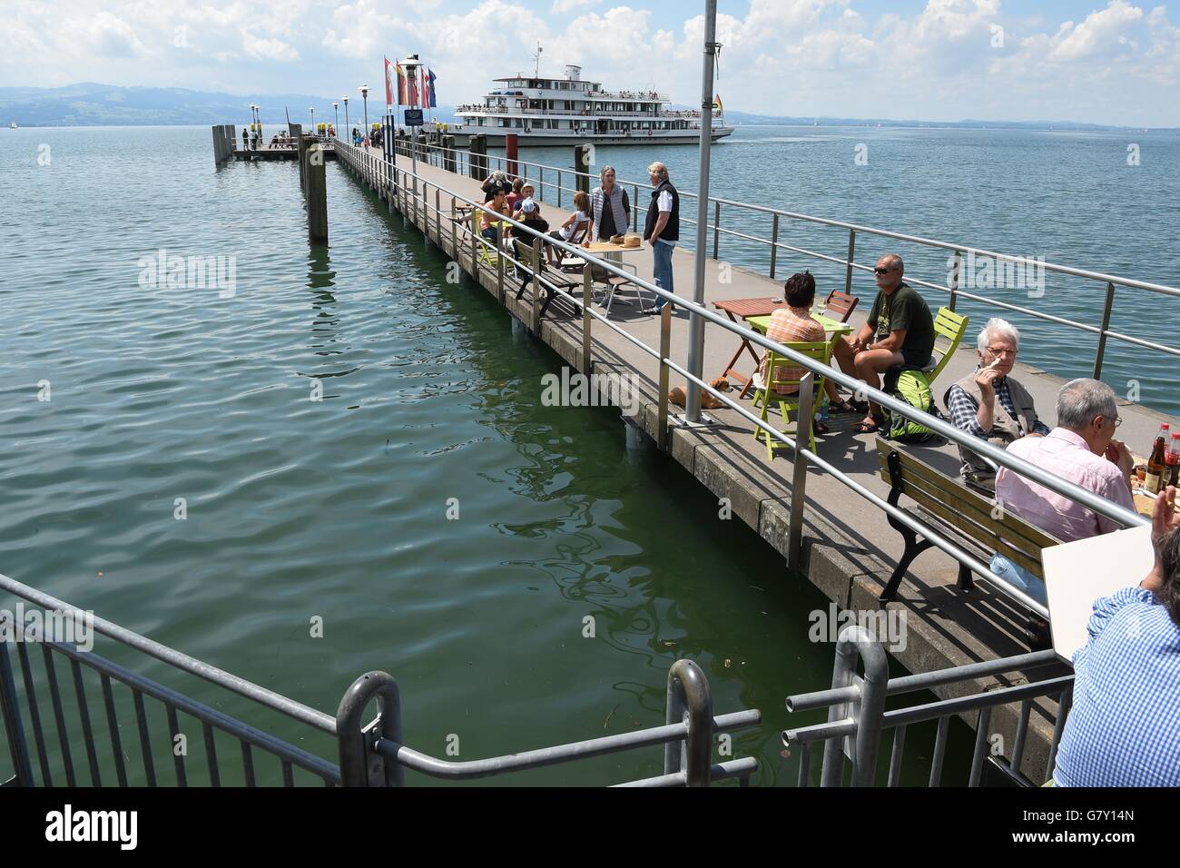 A passenger ship arriving at the jetty in Lake Constance, while several ...
