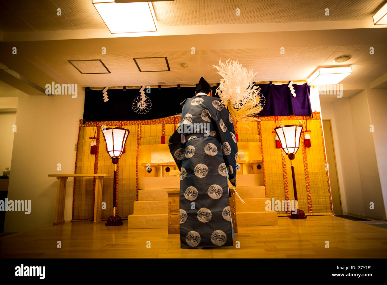 TOKYO, JAPAN - JUNE 27 : A shinto priest staging a prayer to a deceased ...