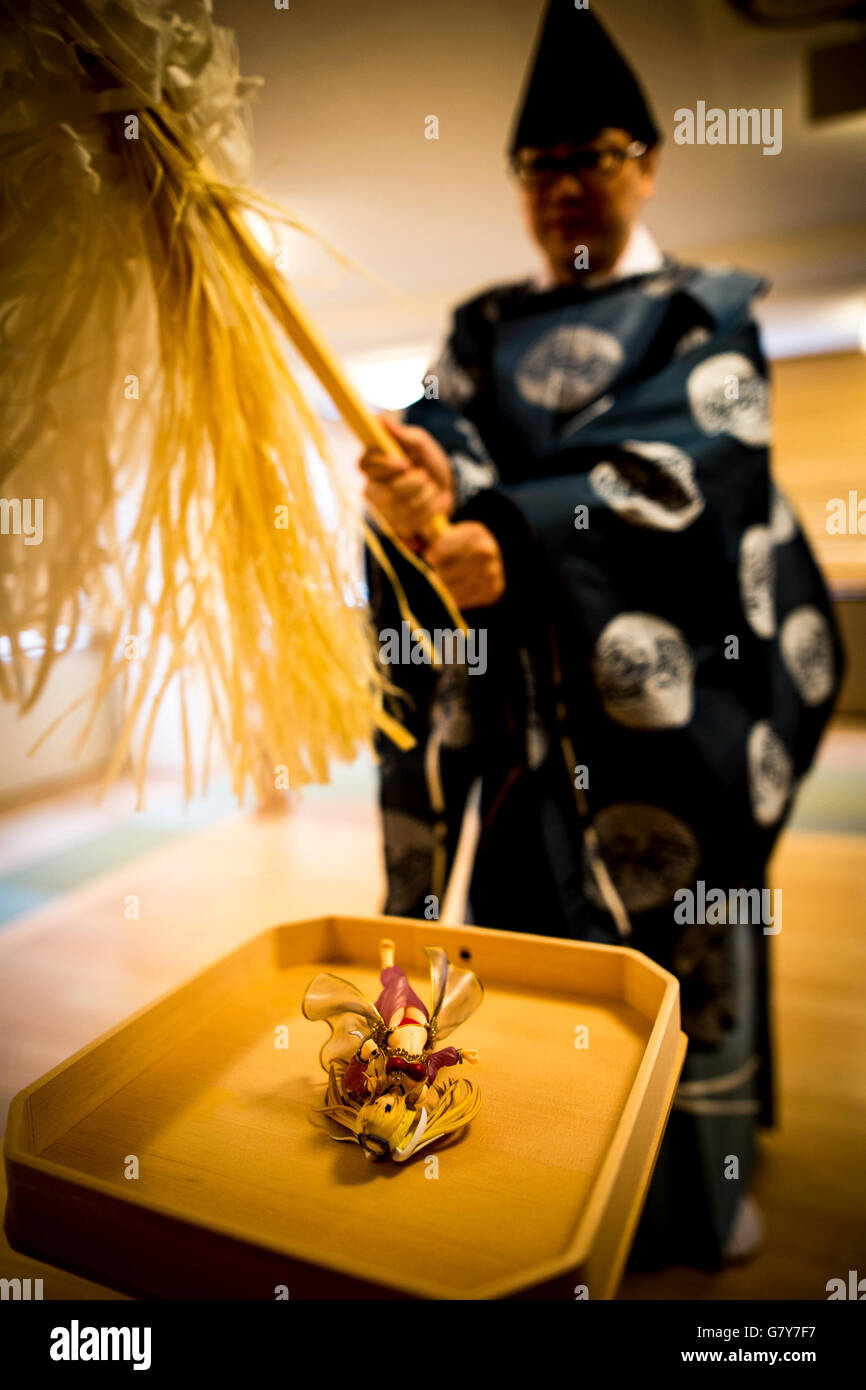 TOKYO, JAPAN - JUNE 27 : A shinto priest staging a prayer to a deceased ...