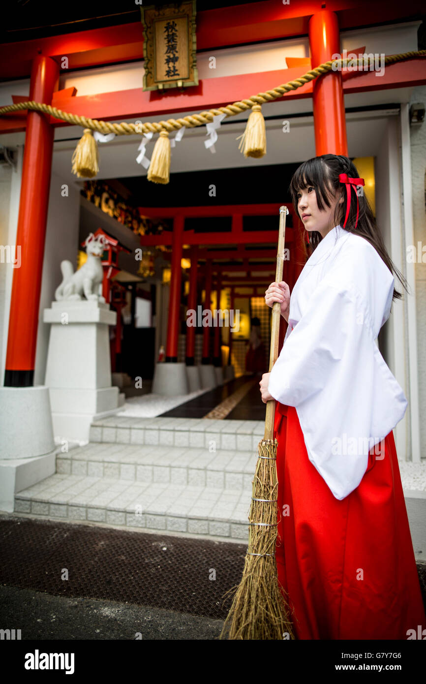 TOKYO, JAPAN - JUNE 27 : A shrine maiden posed for a portrait in front ...