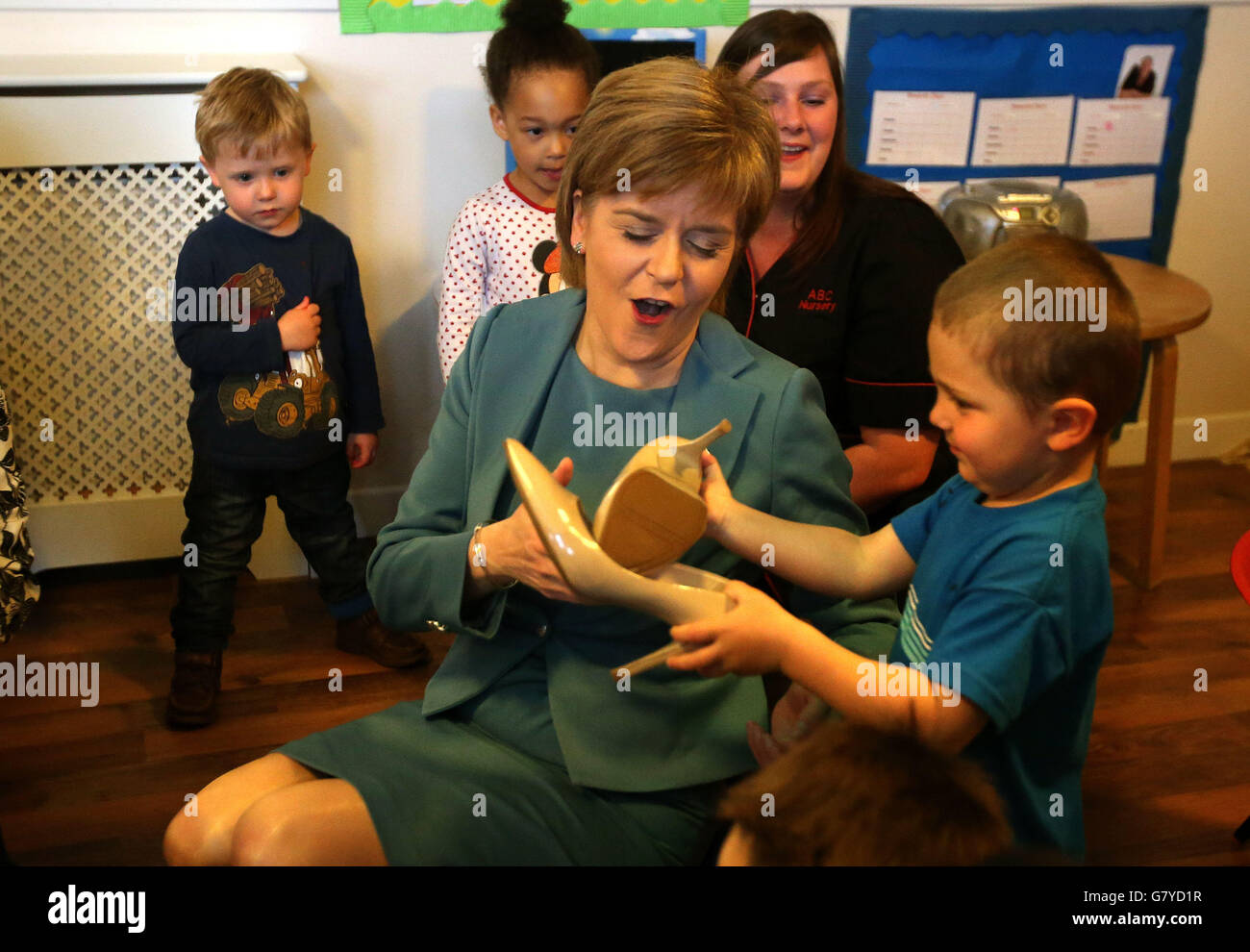 First Minister Nicola Sturgeon is handed her shoes by three-year-old ...