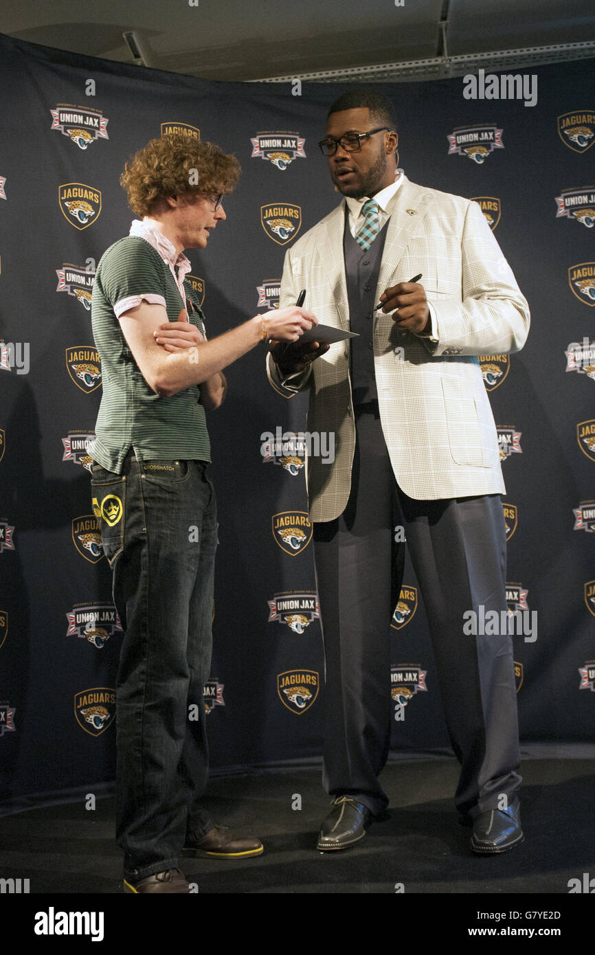 Former Jaguars player Marcus Stroud (right) signs autographs for fans ...