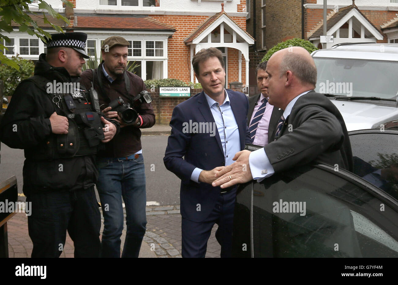 Nick Clegg (centre) arrives back at his home after he earlier resigned ...