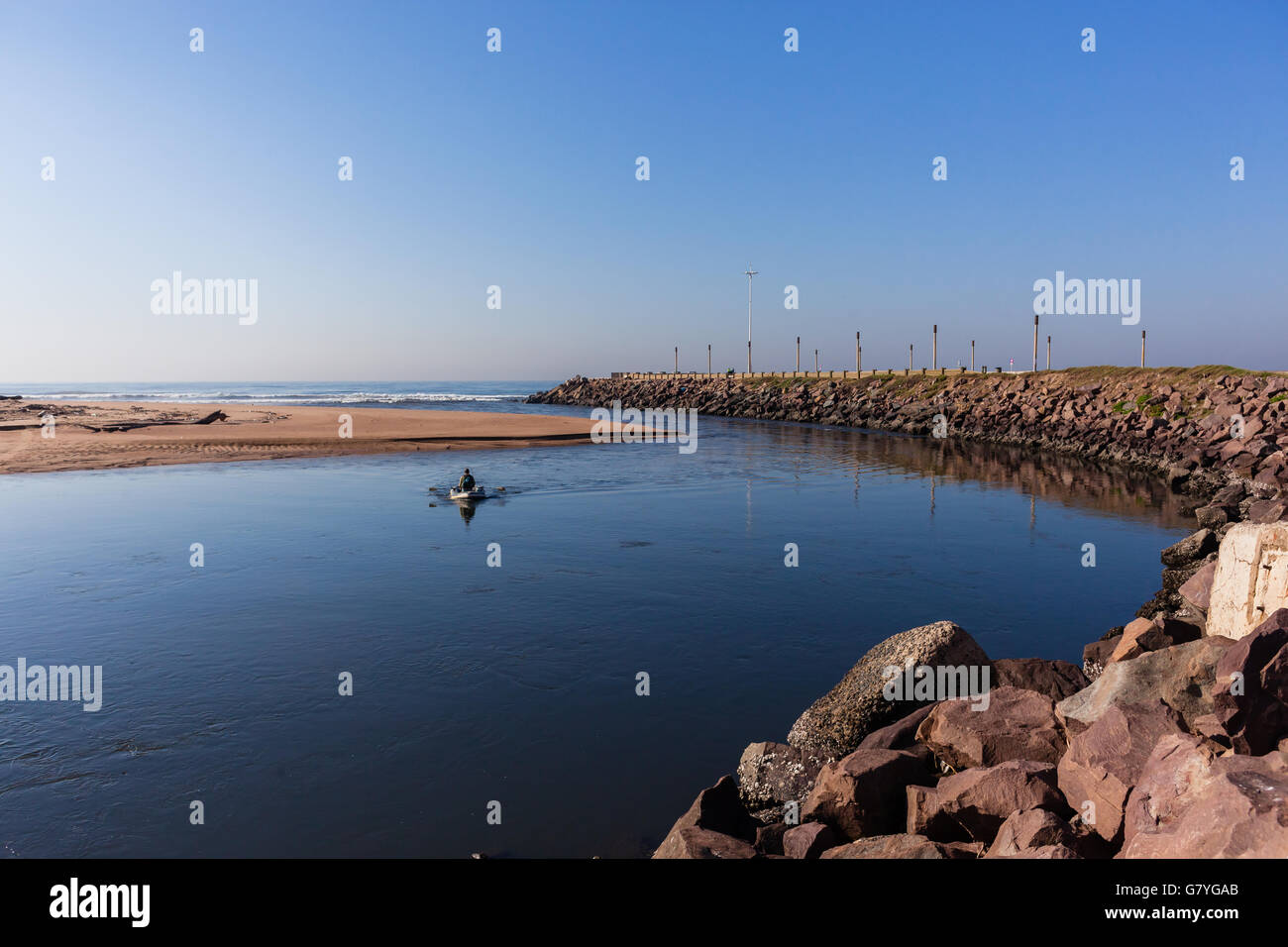 River mouth waters flowing towards blue ocean waves along rocky ...