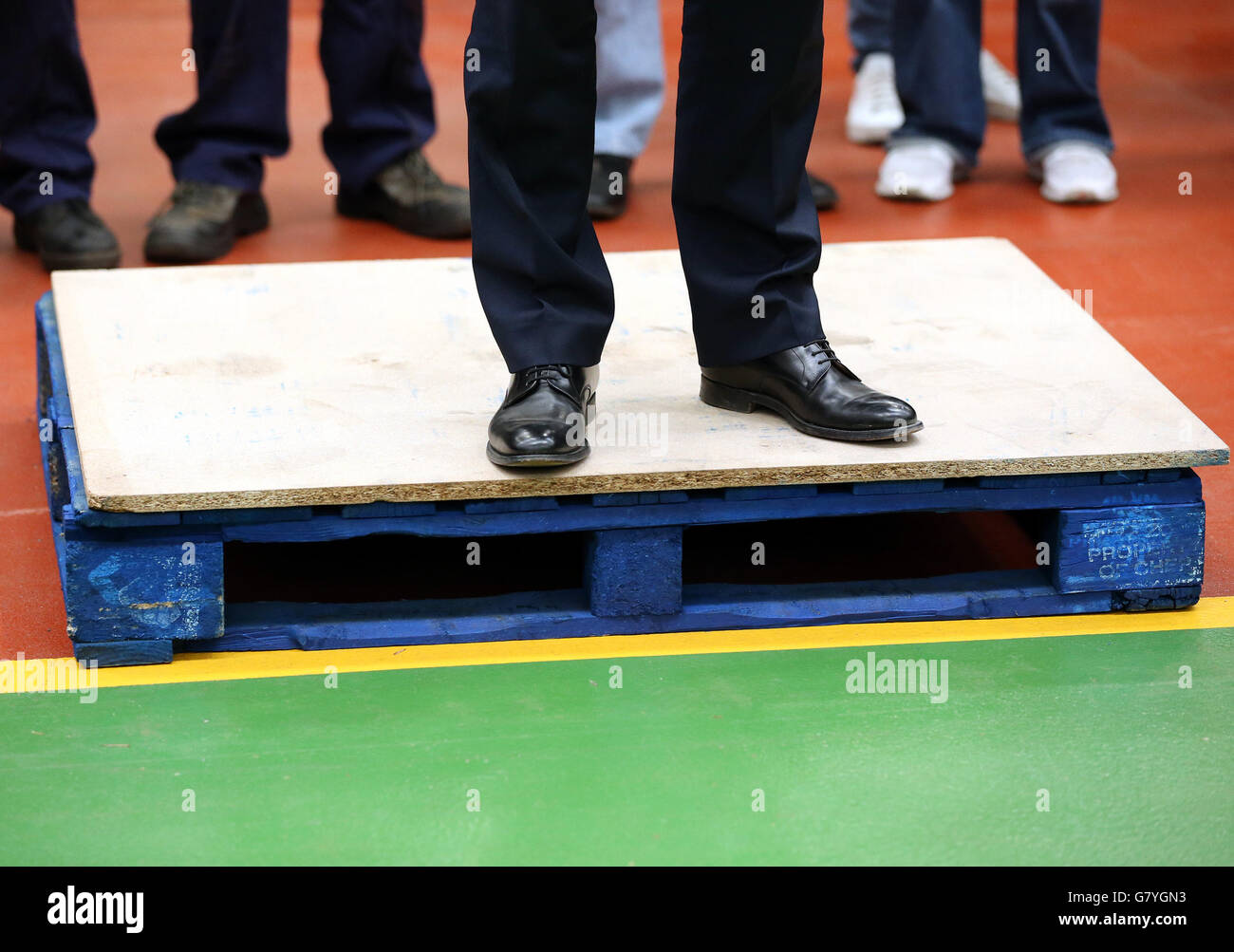 Prime Minister David Cameron stands on a wooden pallet as he talks to ...
