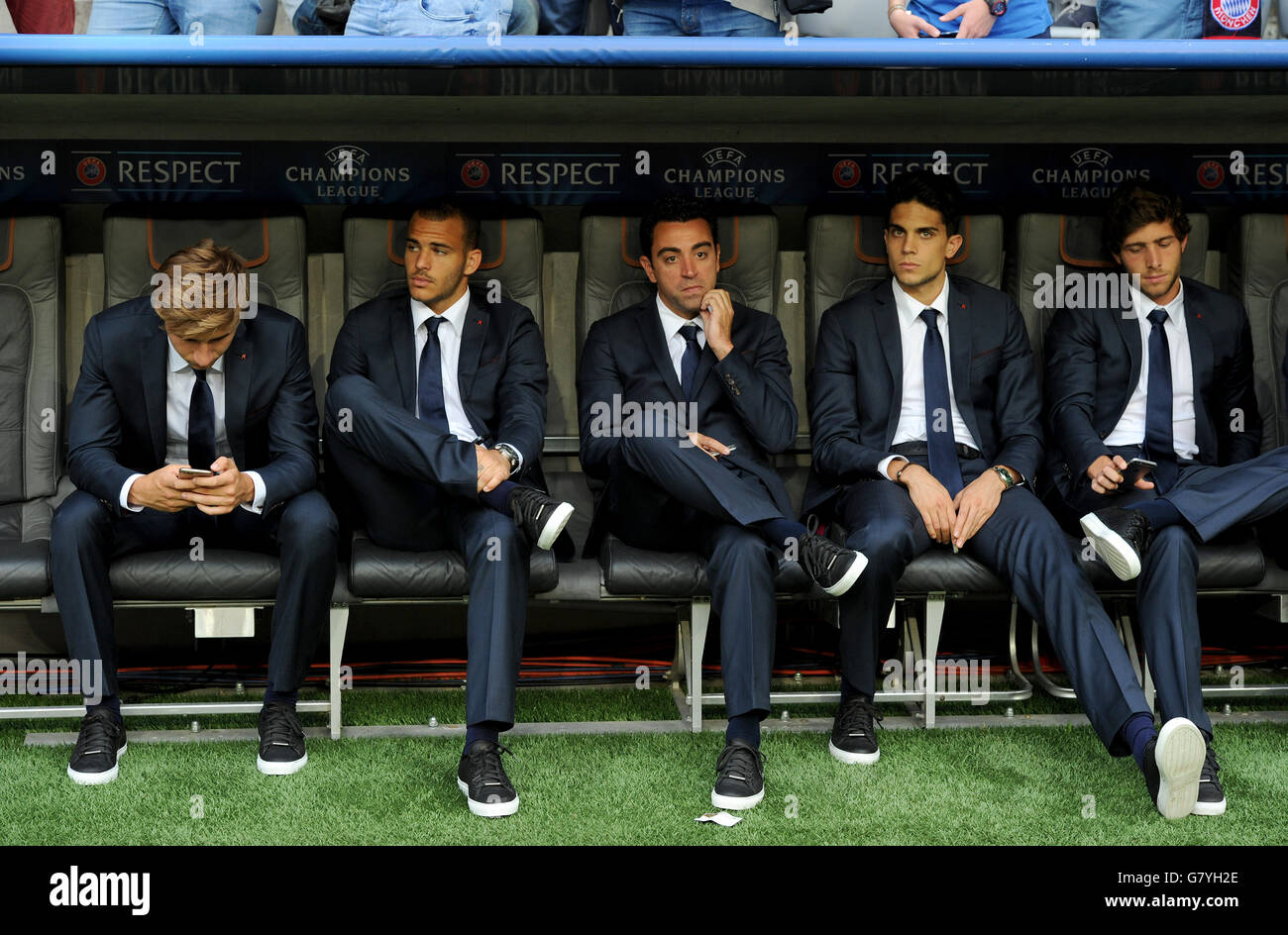 Barcelona's Xavi (centre) sits on the bench in his suit before the ...