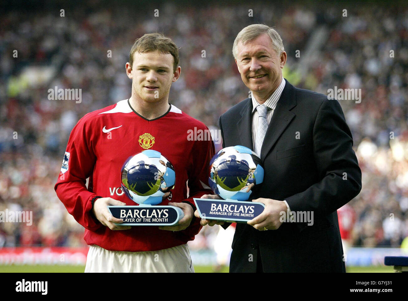 Manchester United's Wayne Rooney (L) with his player of the month award ...
