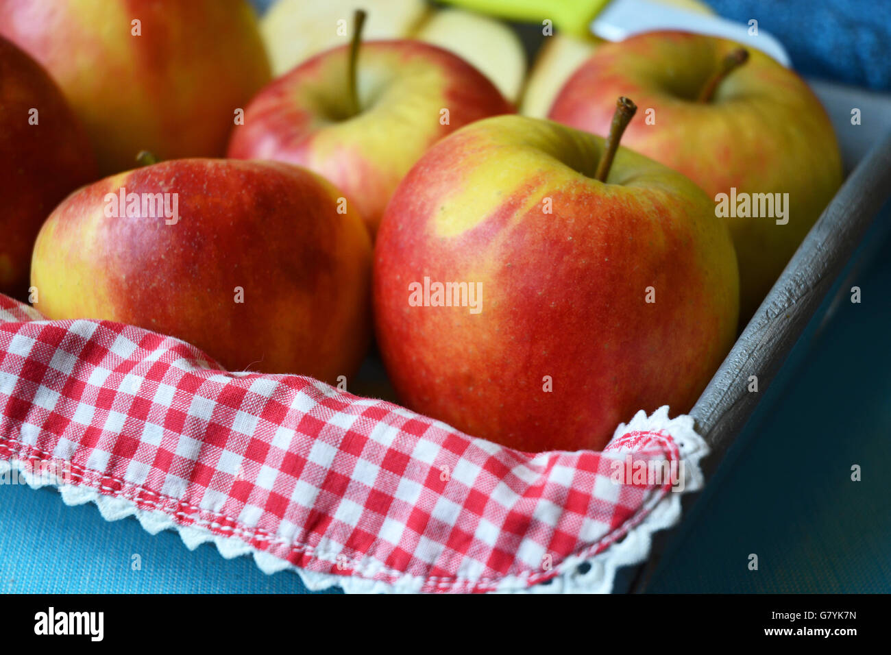 close up of red, yellow ,green apples in wooden bowl with knife and ...