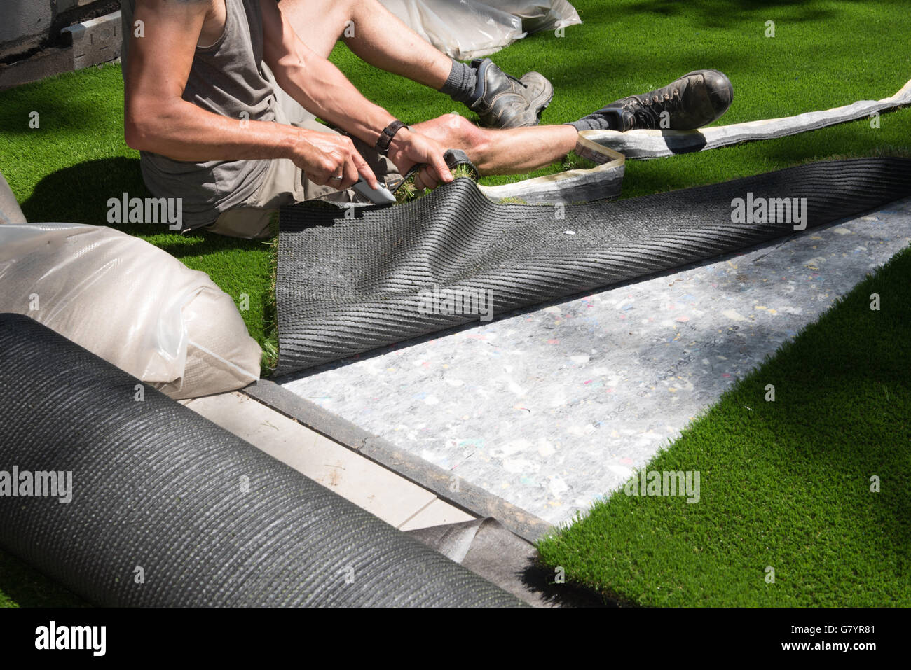 professional gardener is cutting artificial turf to fit Stock Photo - Alamy