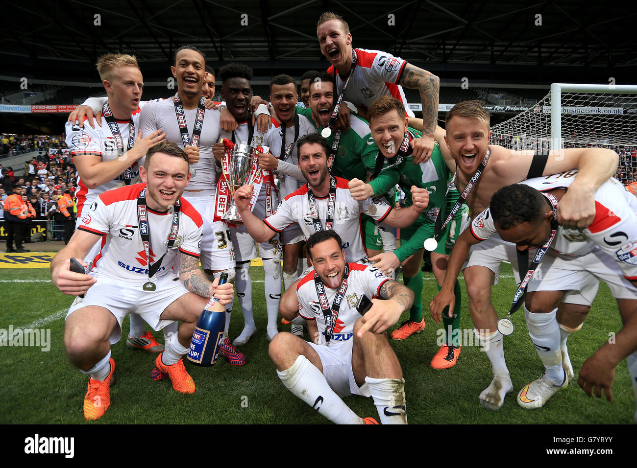 MK Dons players celebrate as their side gain promotion after the Sky ...