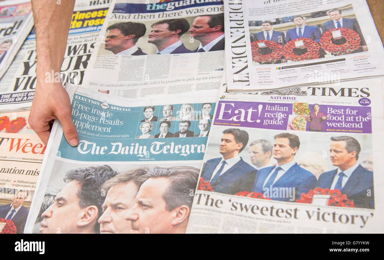 A selection of UK national newspaper front pages, on a news stand in ...