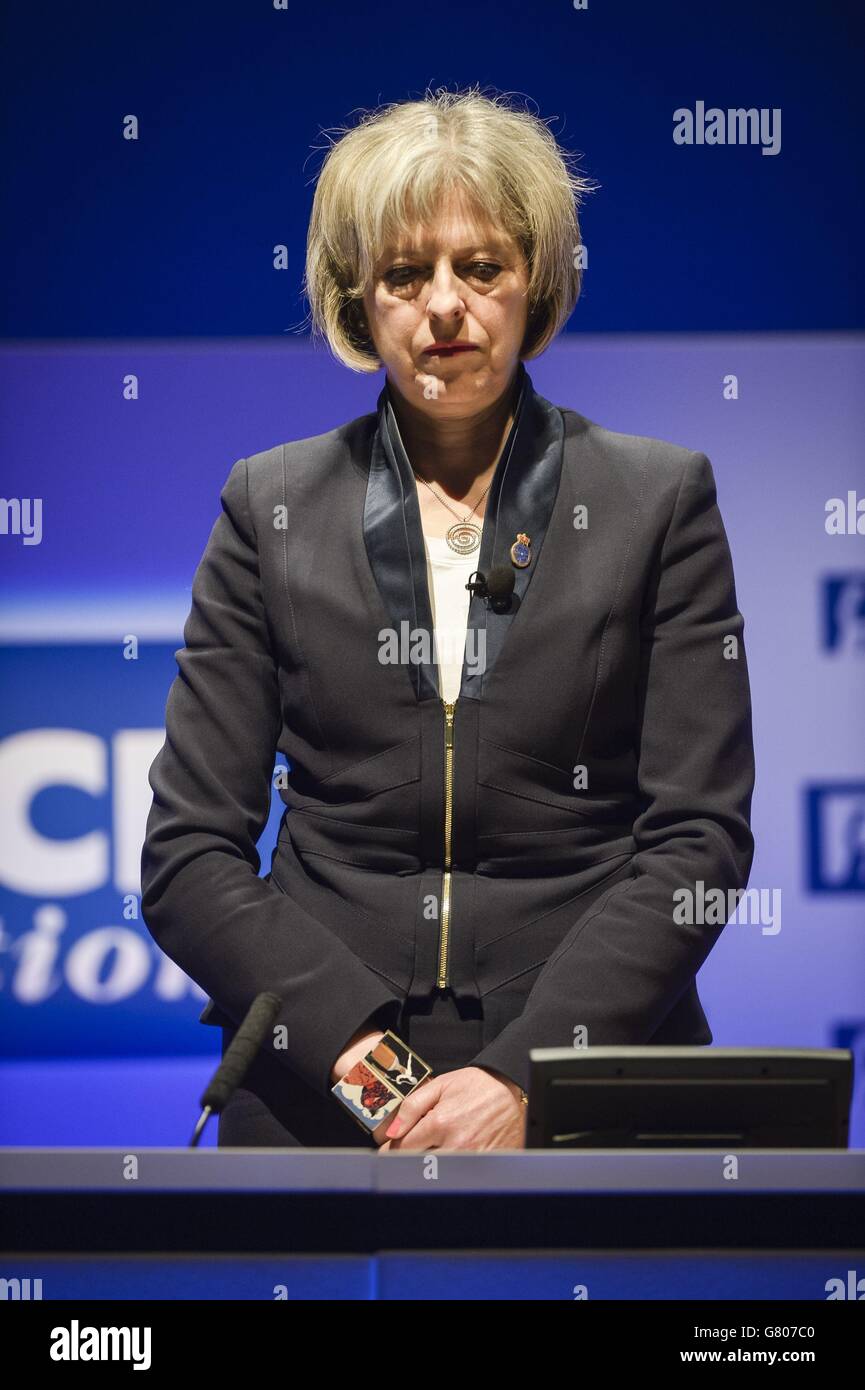 Home Secretary Theresa May stands during a silence honouring three ...