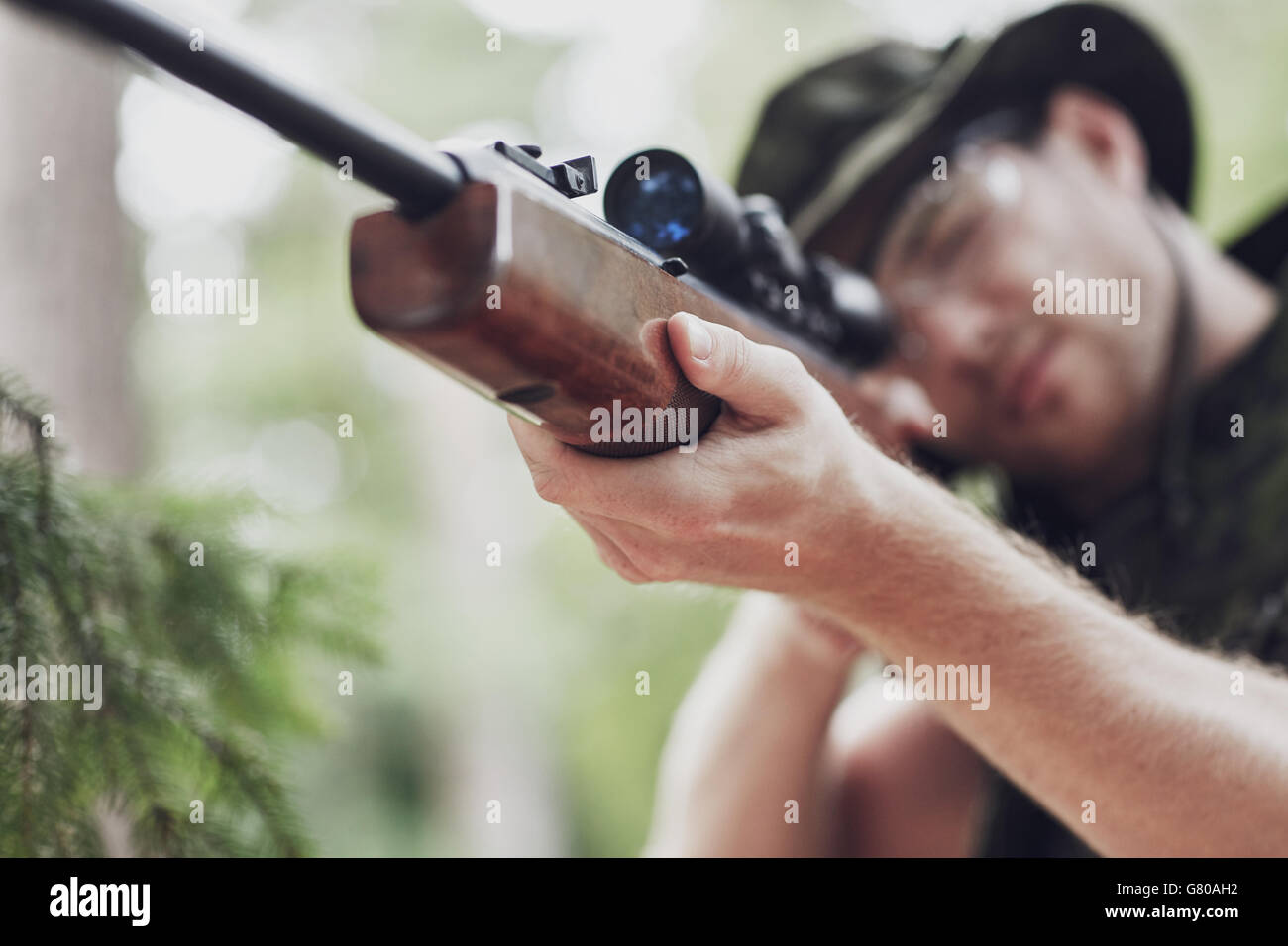 soldier or hunter shooting with gun in forest Stock Photo - Alamy