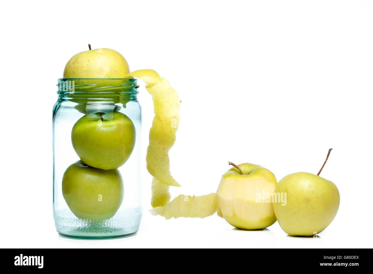 Glass jar full of apples on a white background, showing concept of ...