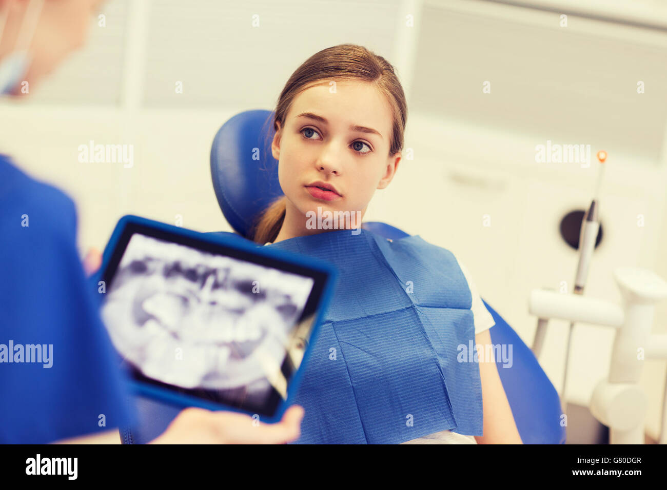 dentist with x-ray on tablet pc and girl patient Stock Photo - Alamy