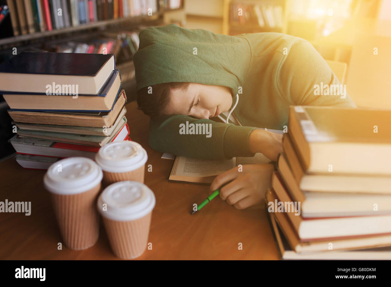 tired student or man with books in library Stock Photo - Alamy