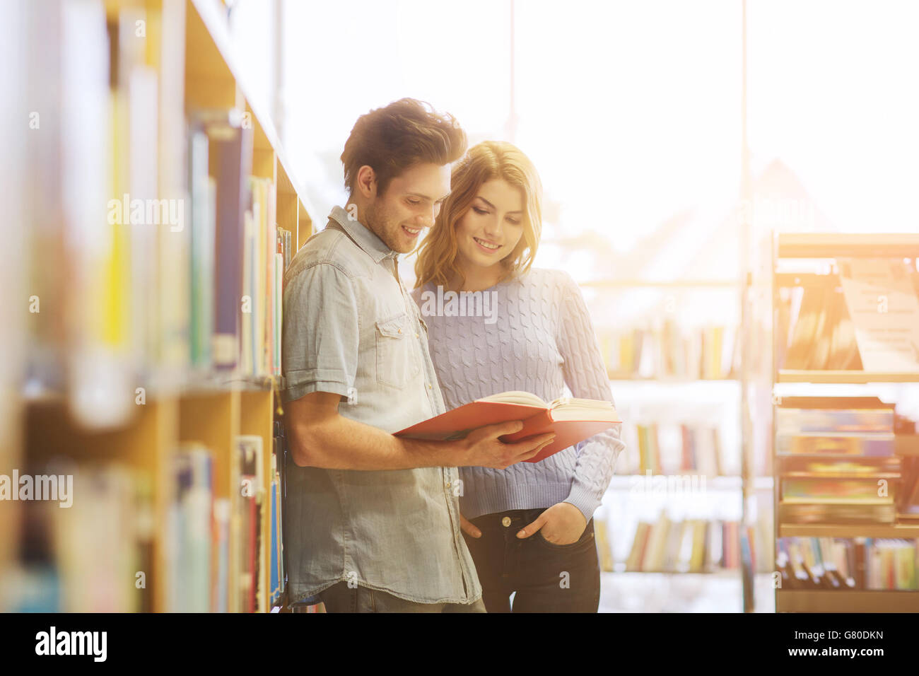 happy student couple with books in library Stock Photo - Alamy