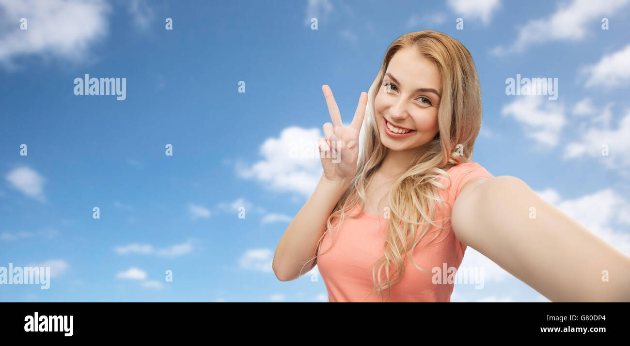 smiling woman taking selfie and showing peace sign Stock Photo - Alamy