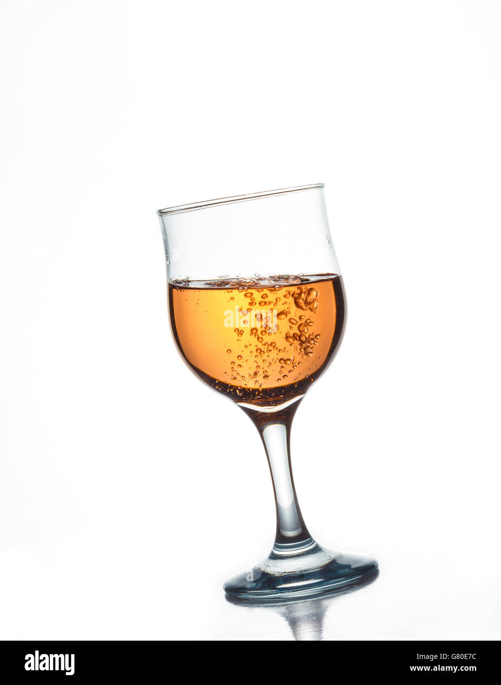 Tilted glass of wine on a white background, sparkling alcoholic ...
