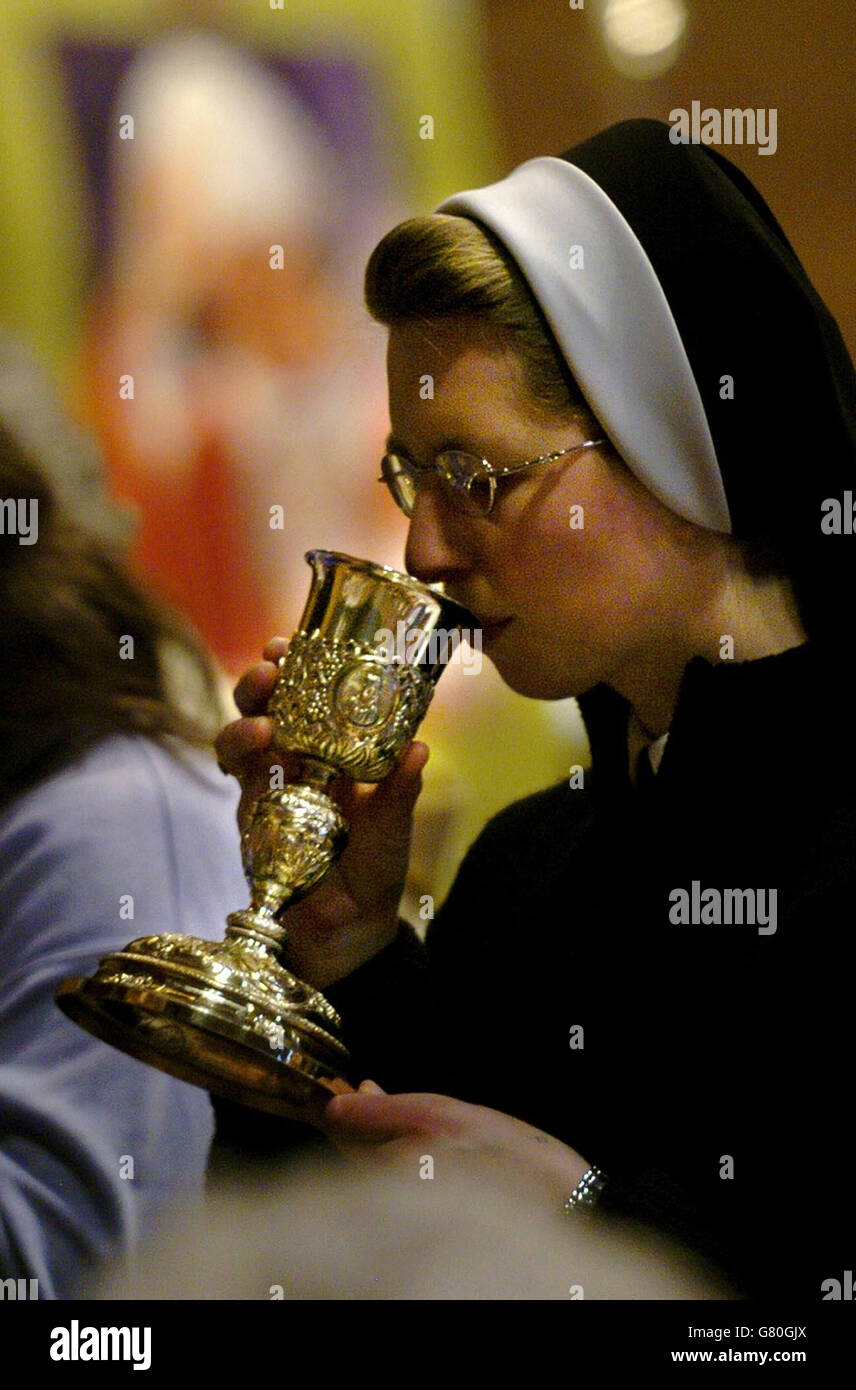 A nun takes communion during midday mass led by Father Noel Wynn to ...