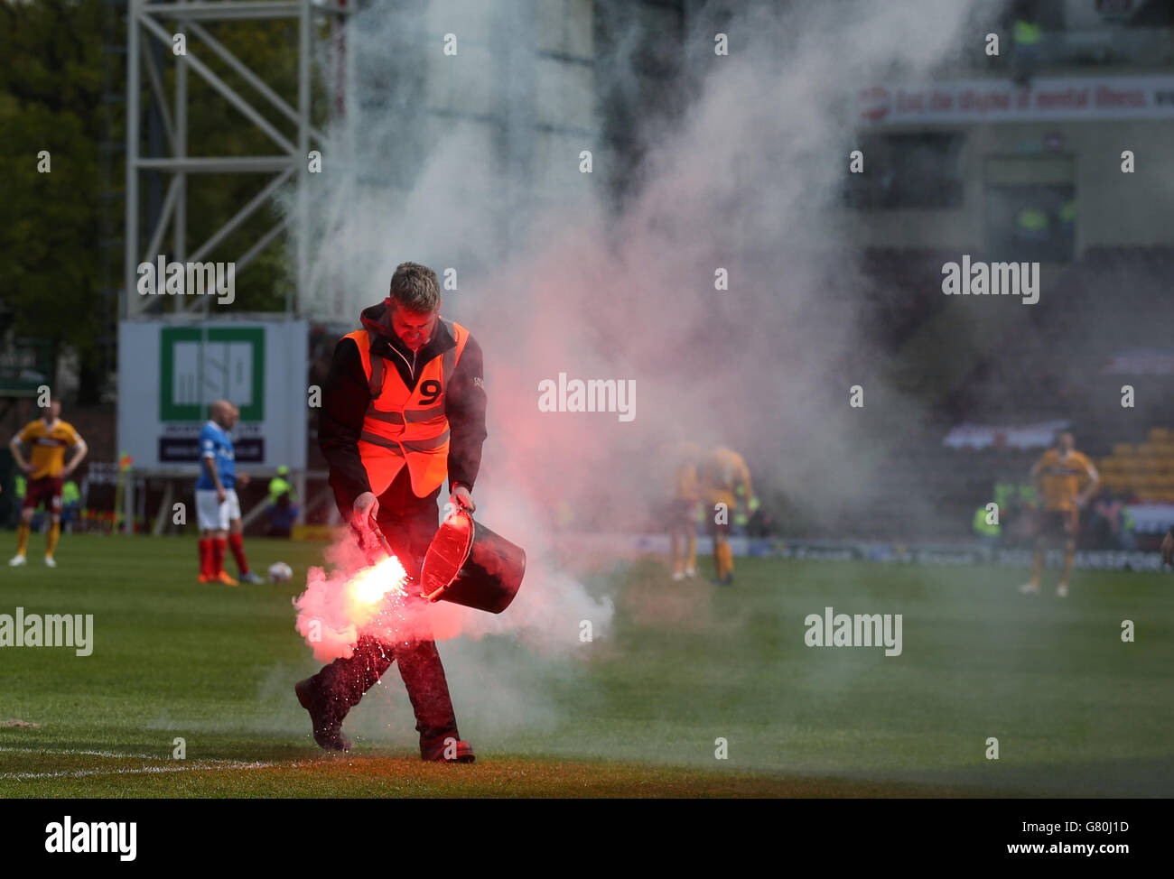 A flare is picked up after being thrown onto the pitch during the ...