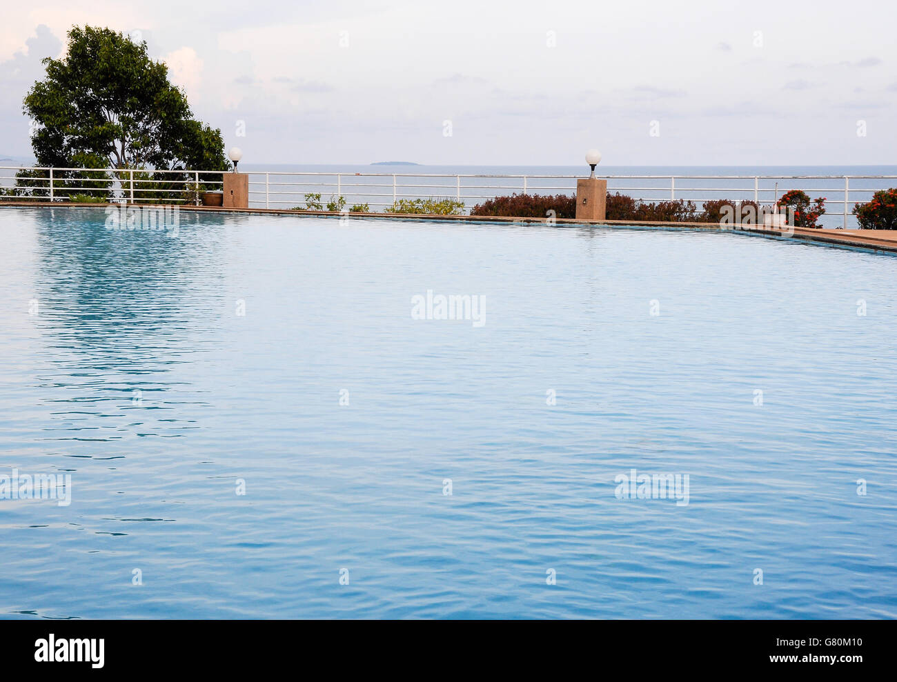 Tranquil swimming pool beside the blue sea in the hotel Stock Photo - Alamy