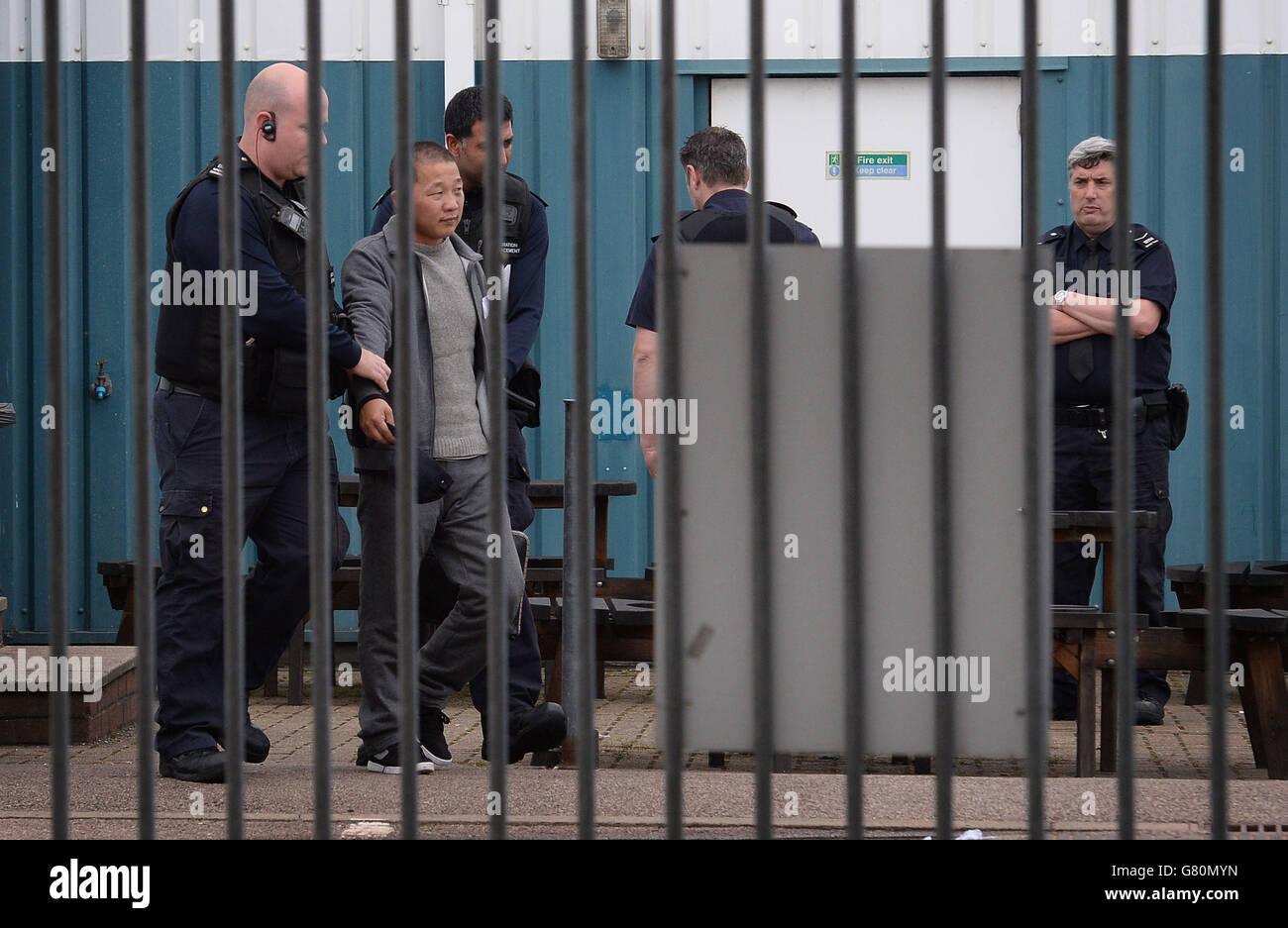 A man is led away by Border Force staff at Harwich International port ...