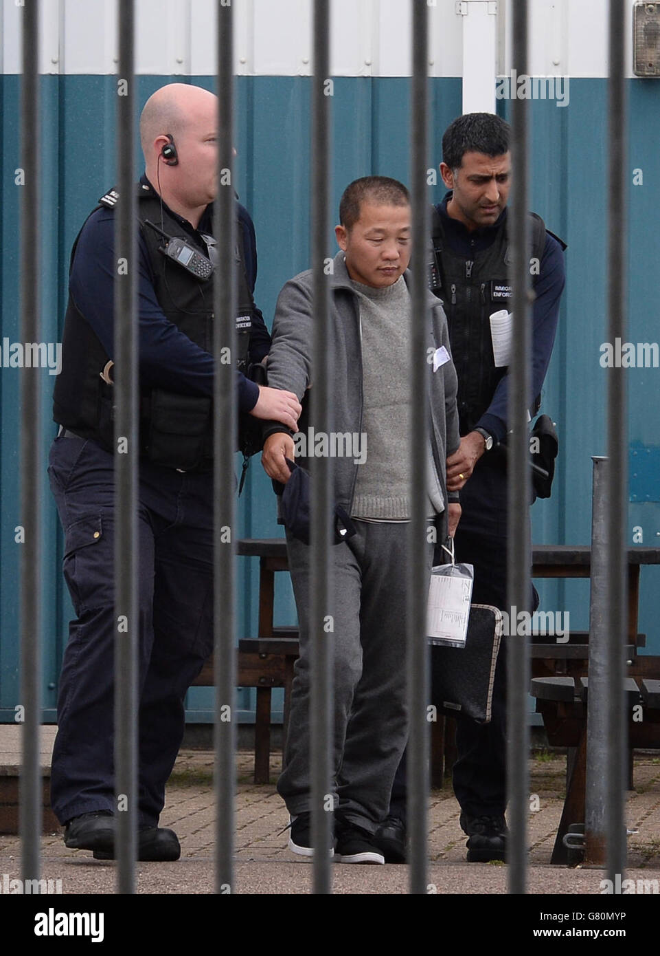 A man is led away by Border Force staff at Harwich International port ...