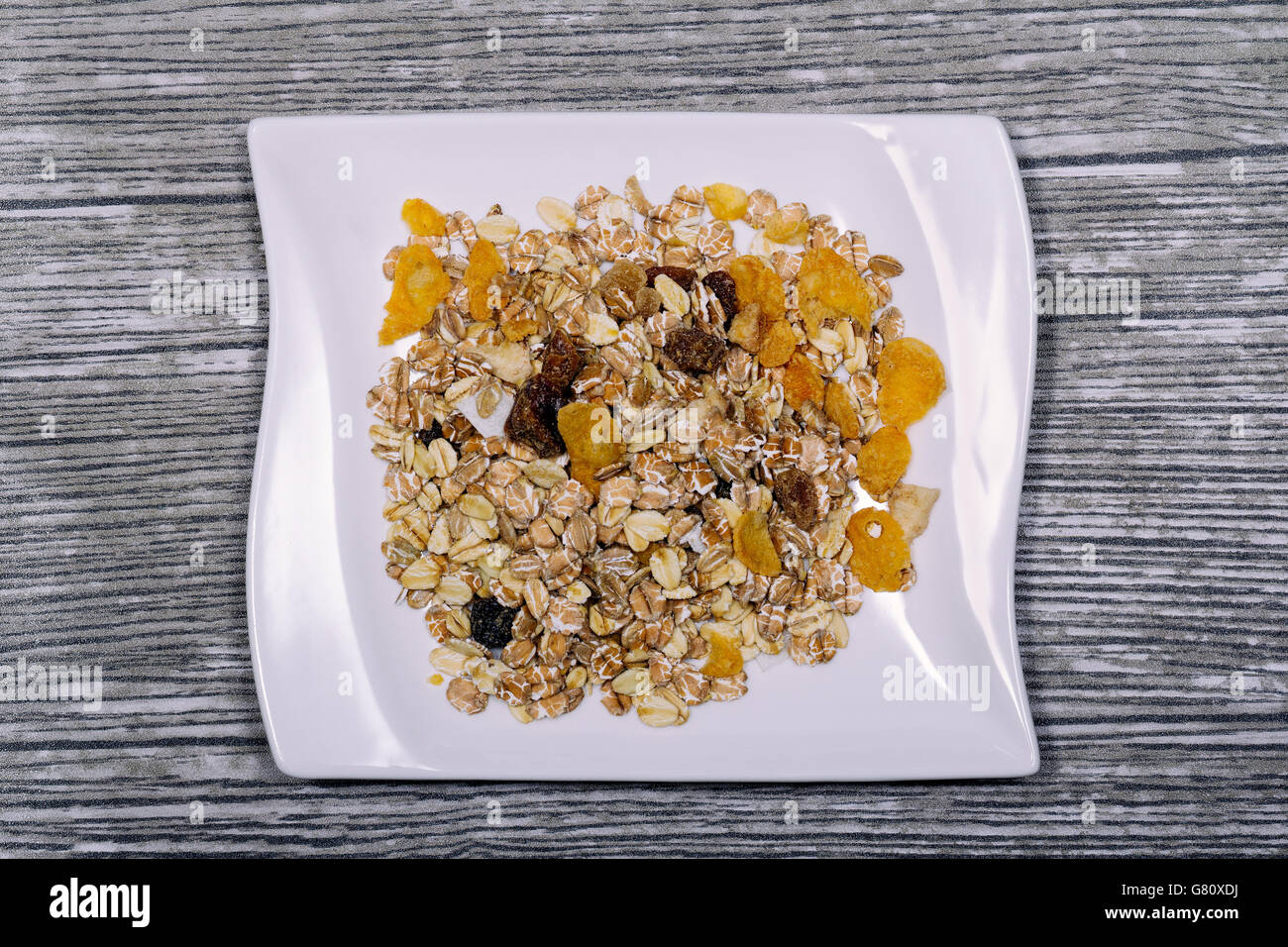 Healthy cereals for breakfast on white plate and glass bowl on a ...