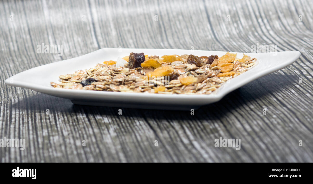 Healthy cereals for breakfast on white plate and glass bowl on a ...