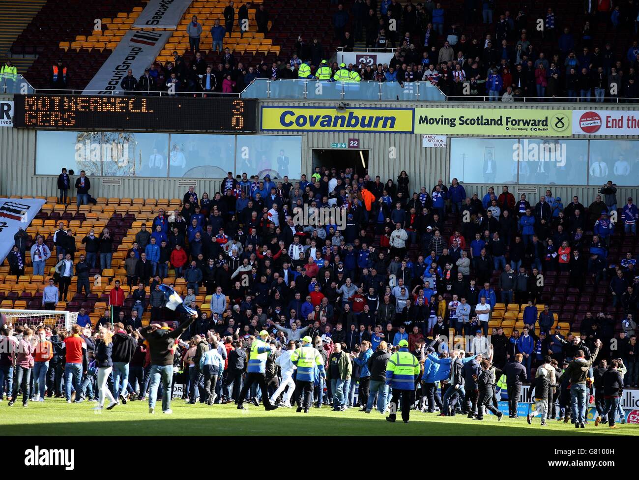 Motherwell fans on the pitch are watched by Rangers fans in the stands ...