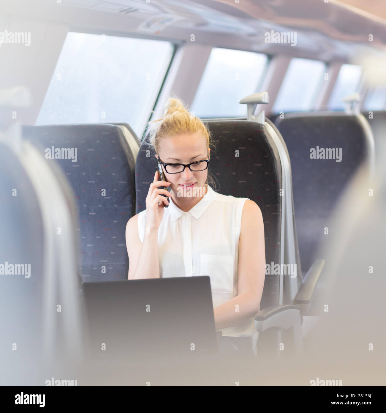 Business woman working while travelling by train Stock Photo - Alamy