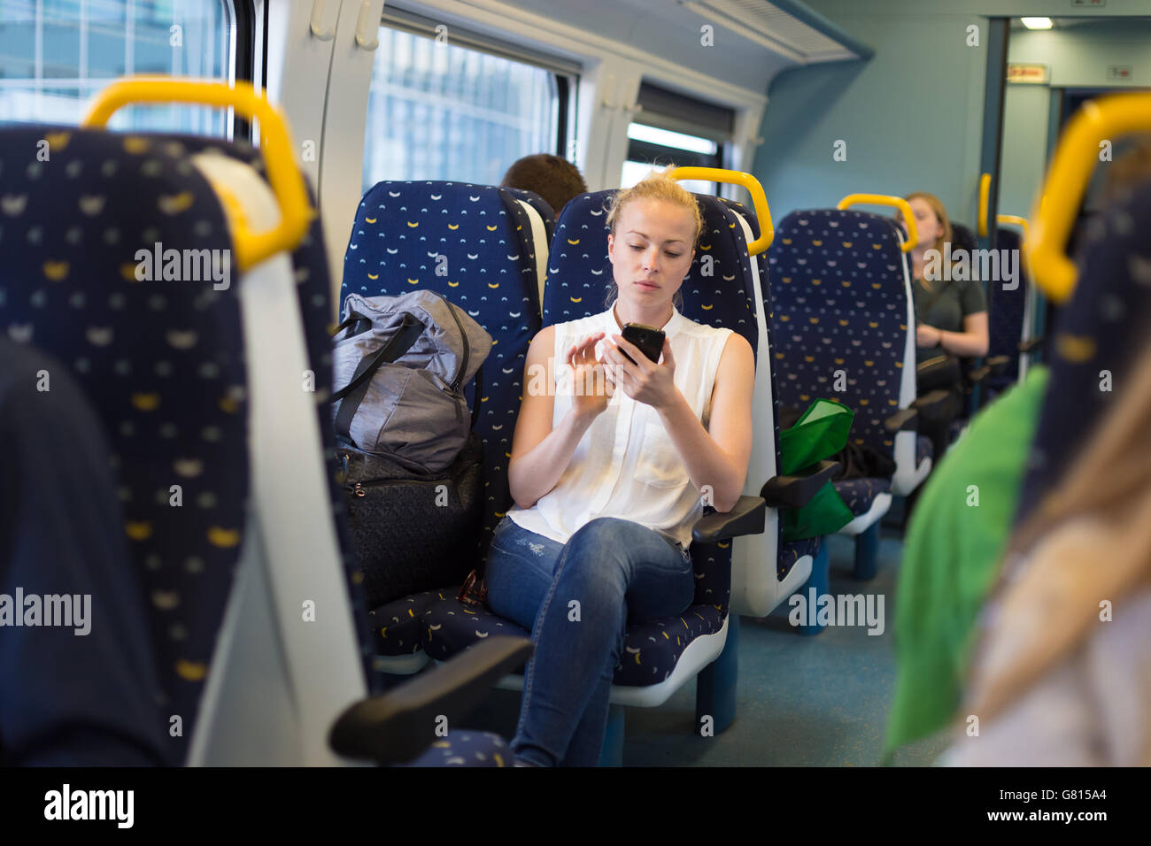 Woman using mobile phone while travelling by train Stock Photo - Alamy