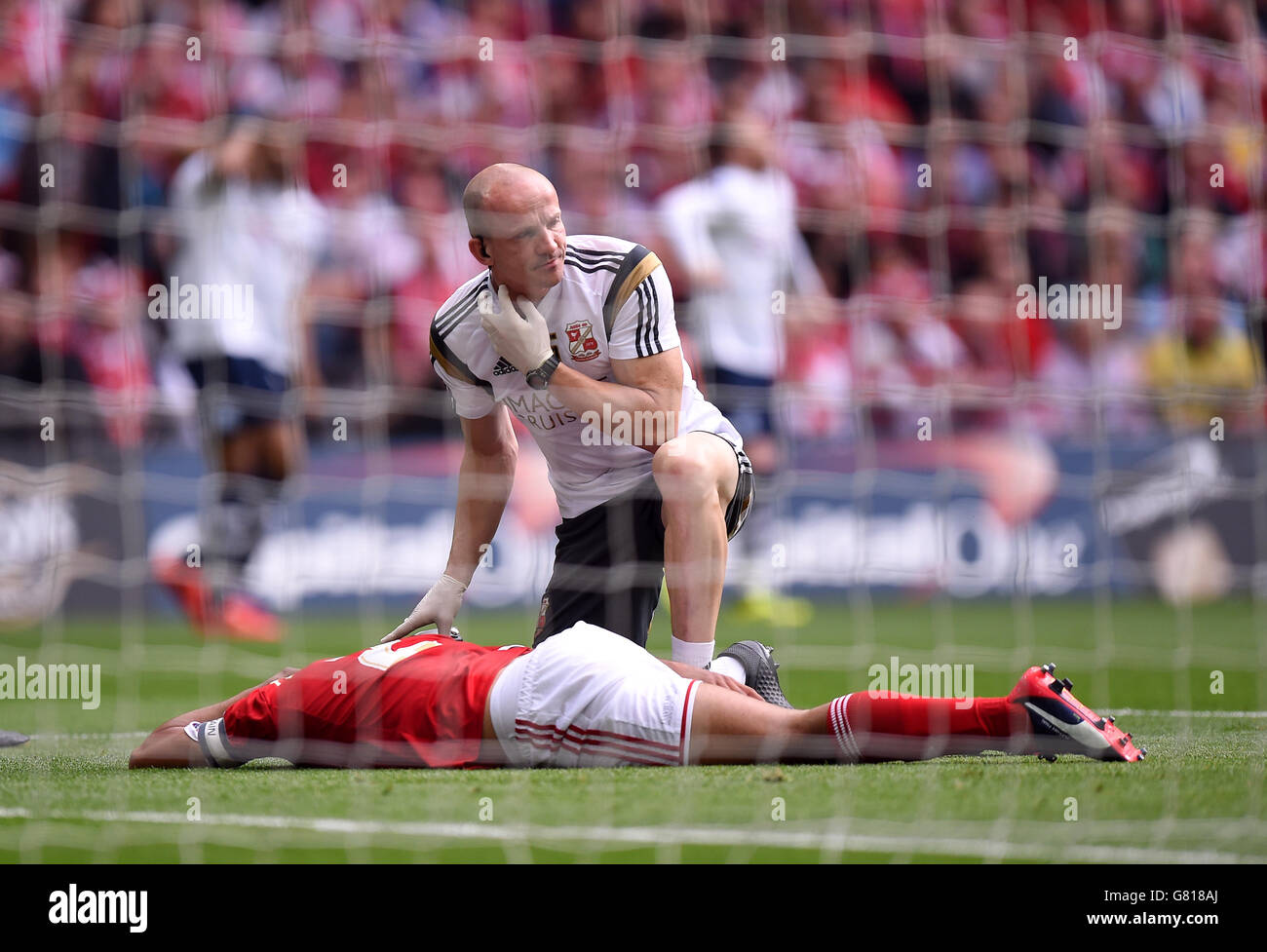 Swindon Town's Nathan Thompson is checked on by the medic before ...