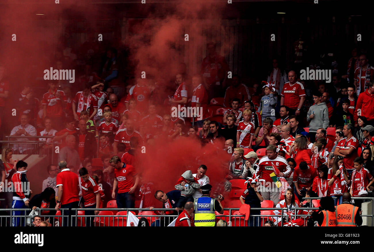 A young fan has to be lifted clear as Middlesbrough fans let off a ...