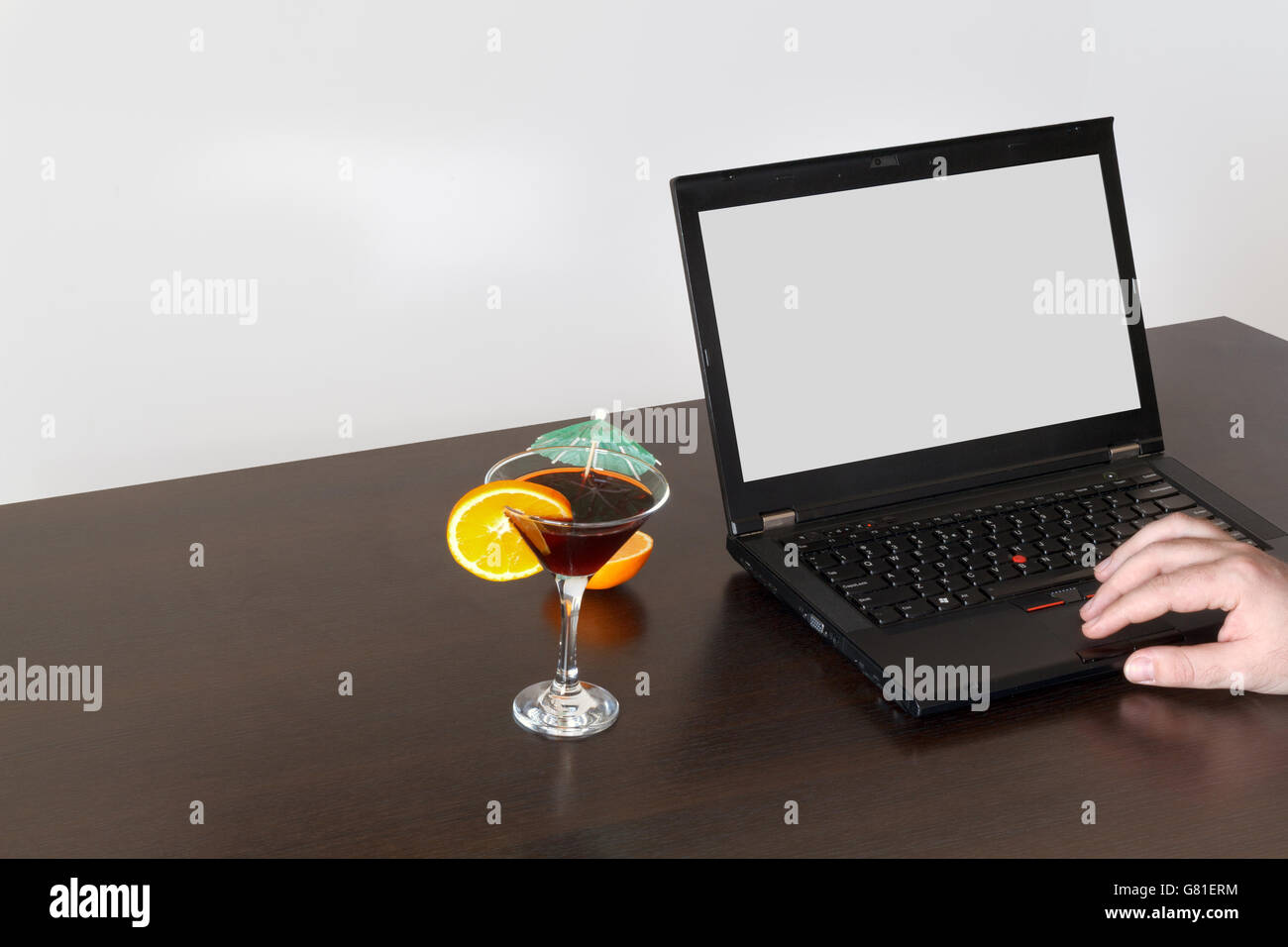 Laptop with white screen for copy on a table next to a glass of ...