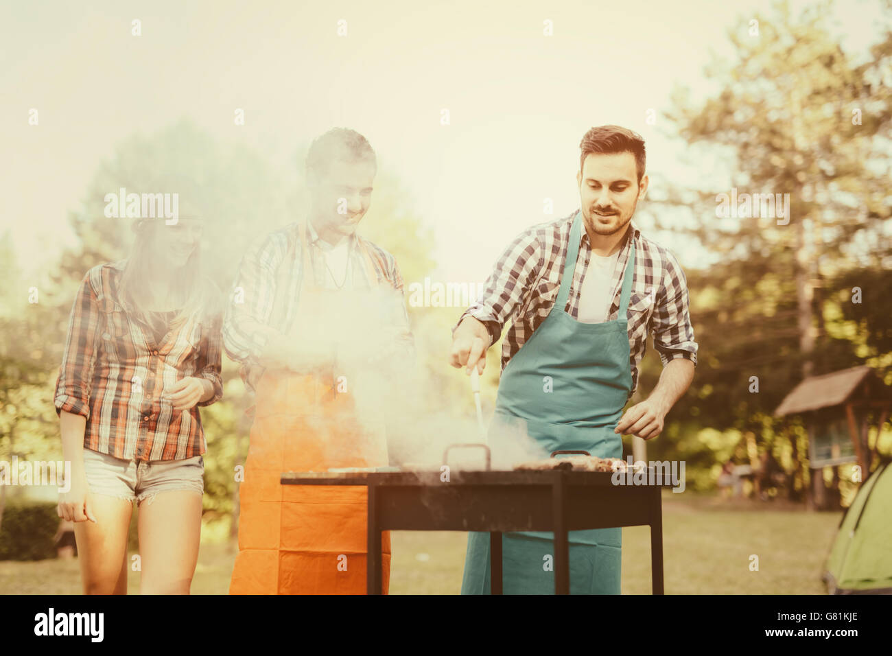 Young people enjoying barbecuing Stock Photo - Alamy