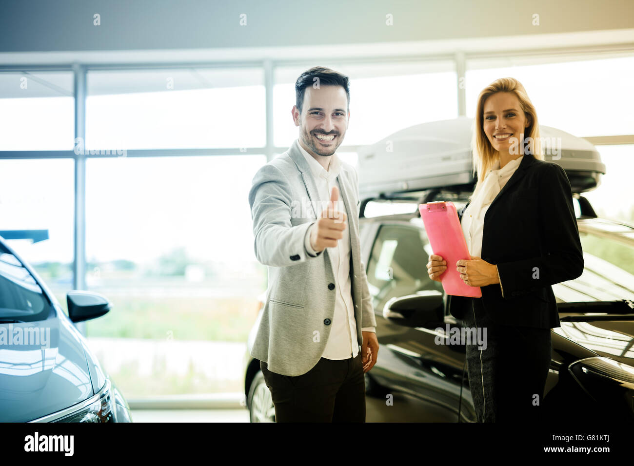 Car salesperson assisting customer at car dealership Stock Photo - Alamy