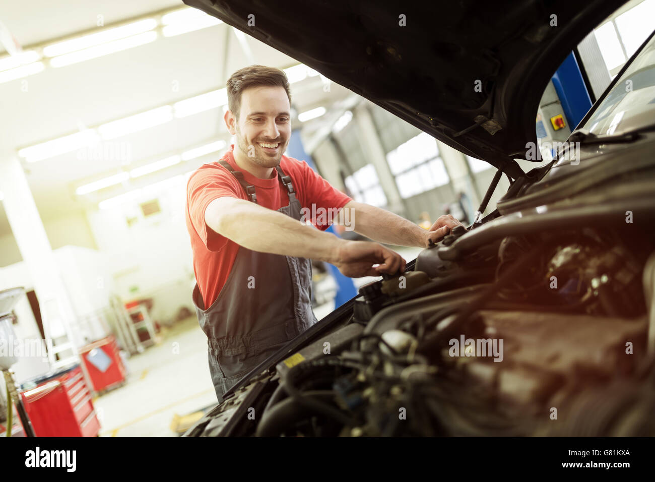 Car mechanic fixing a car in garage at dealership Stock Photo - Alamy