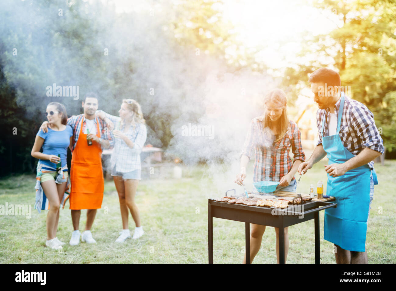 Young people enjoying barbecuing Stock Photo - Alamy