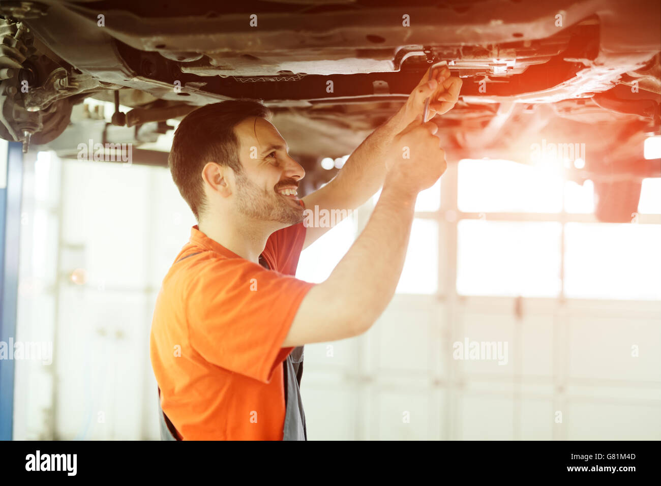 Car mechanic fixing a car in garage at dealership Stock Photo - Alamy