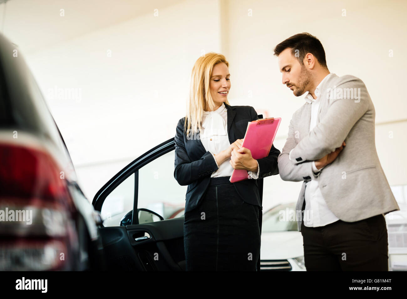Customer looking for a car at dealership and customizing vehicle Stock ...